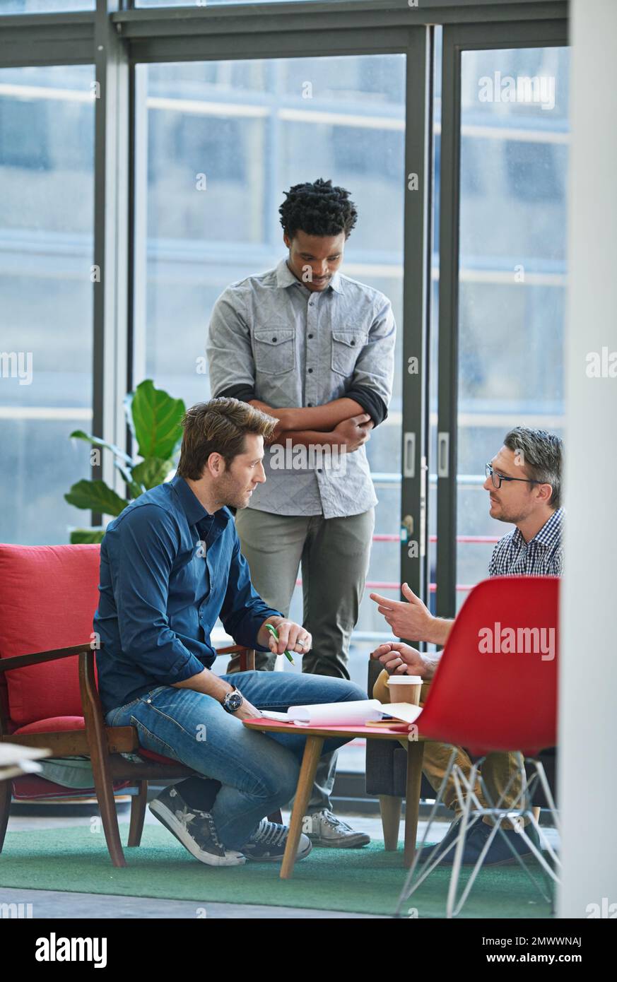 Planning before action. a group of office workers talking together in a ...