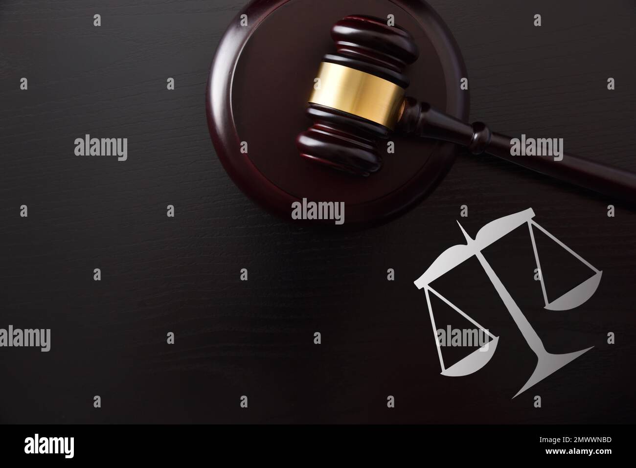 Symbolic objects of justice such as gavel and balance on black wooden ...