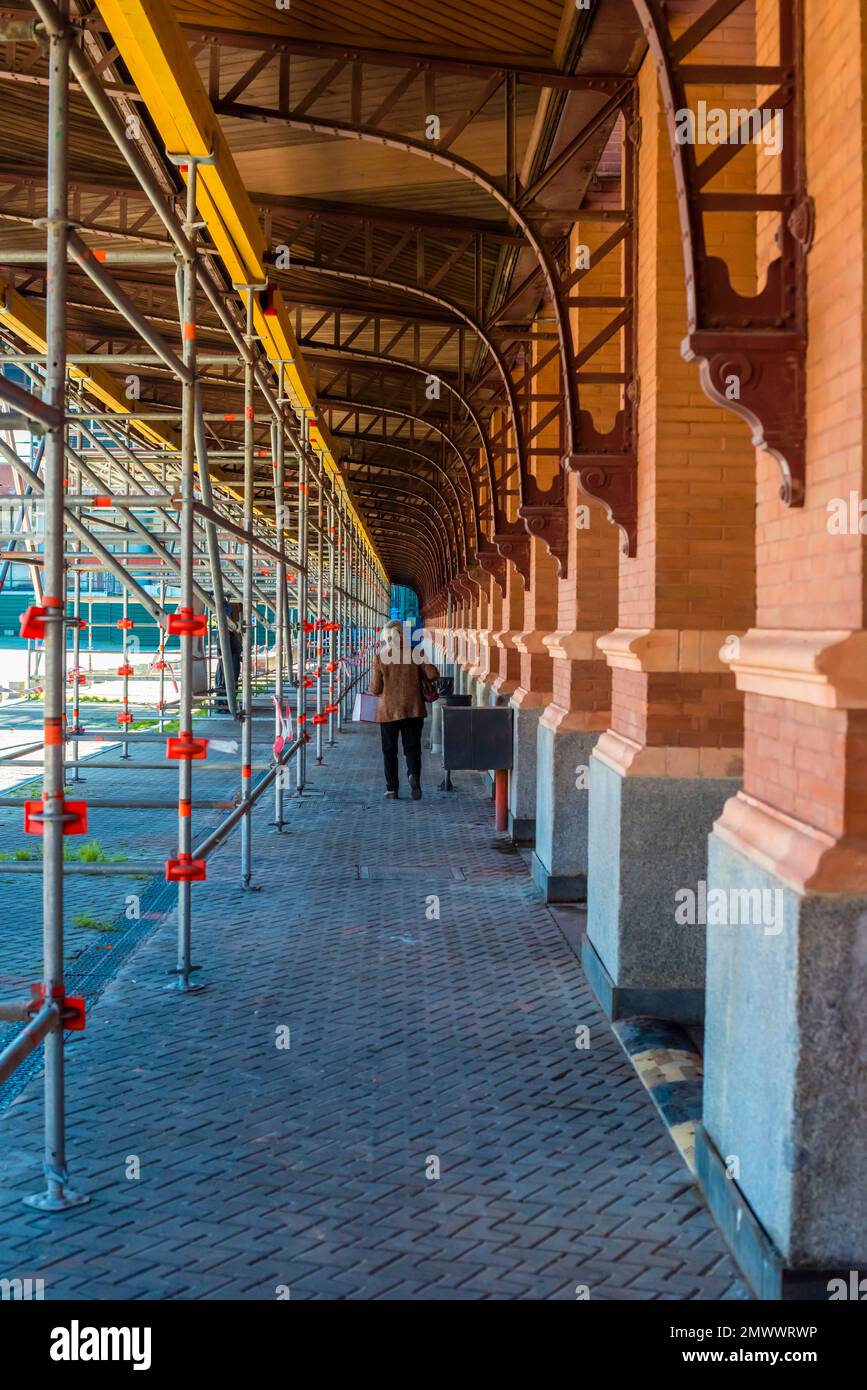 A vertical view of a person walling under the scaffolding erected ...