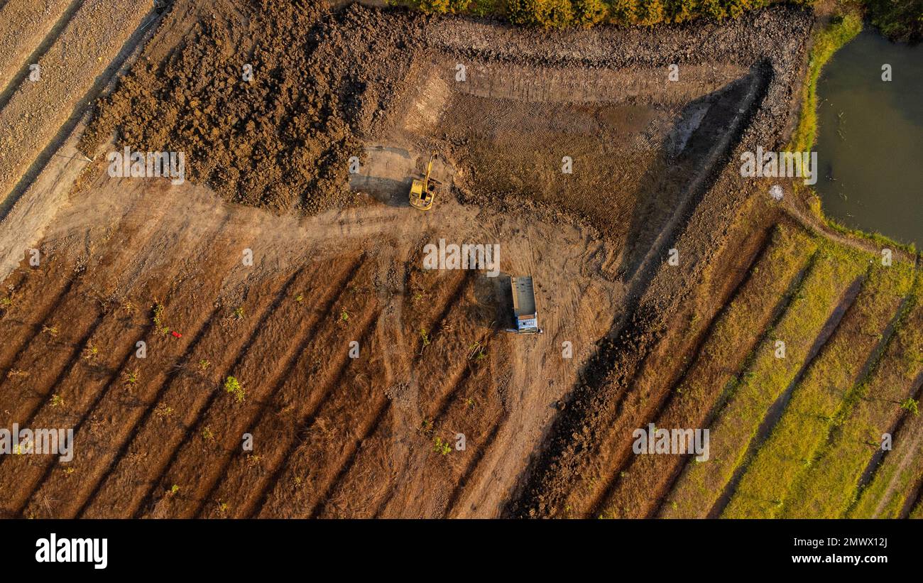 Aerial view of a wheel loader excavator with a backhoe loading sand ...