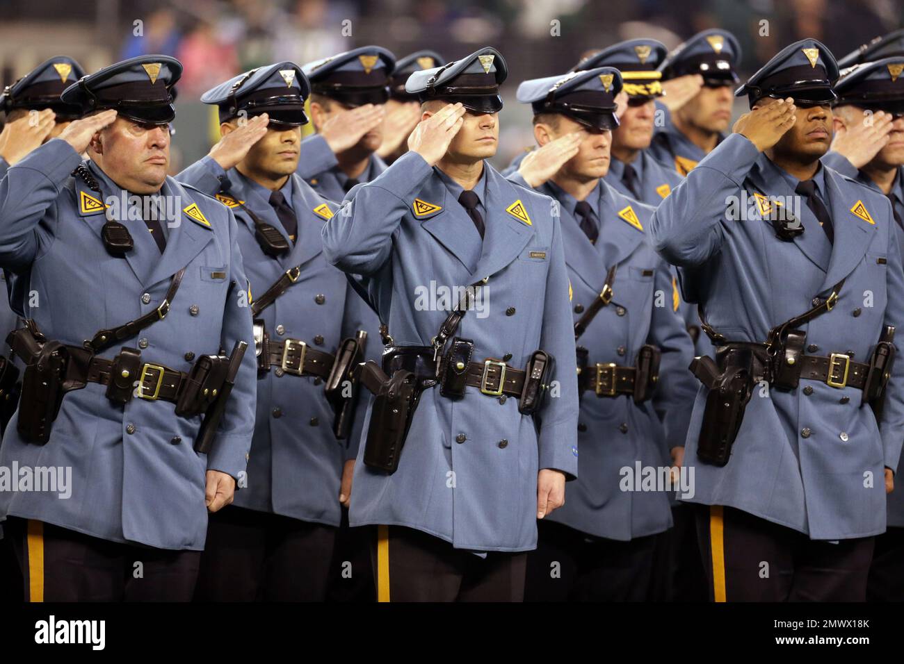 New Jersey State Police officers salute prior to the start of an NFL ...
