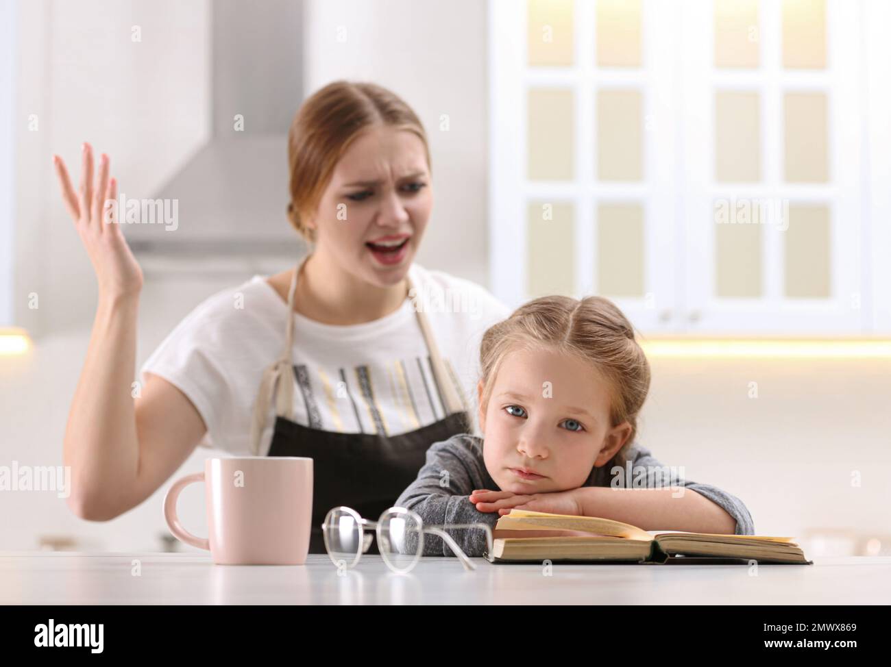 Mother scolding her daughter while helping with homework in kitchen Stock Photo - Alamy