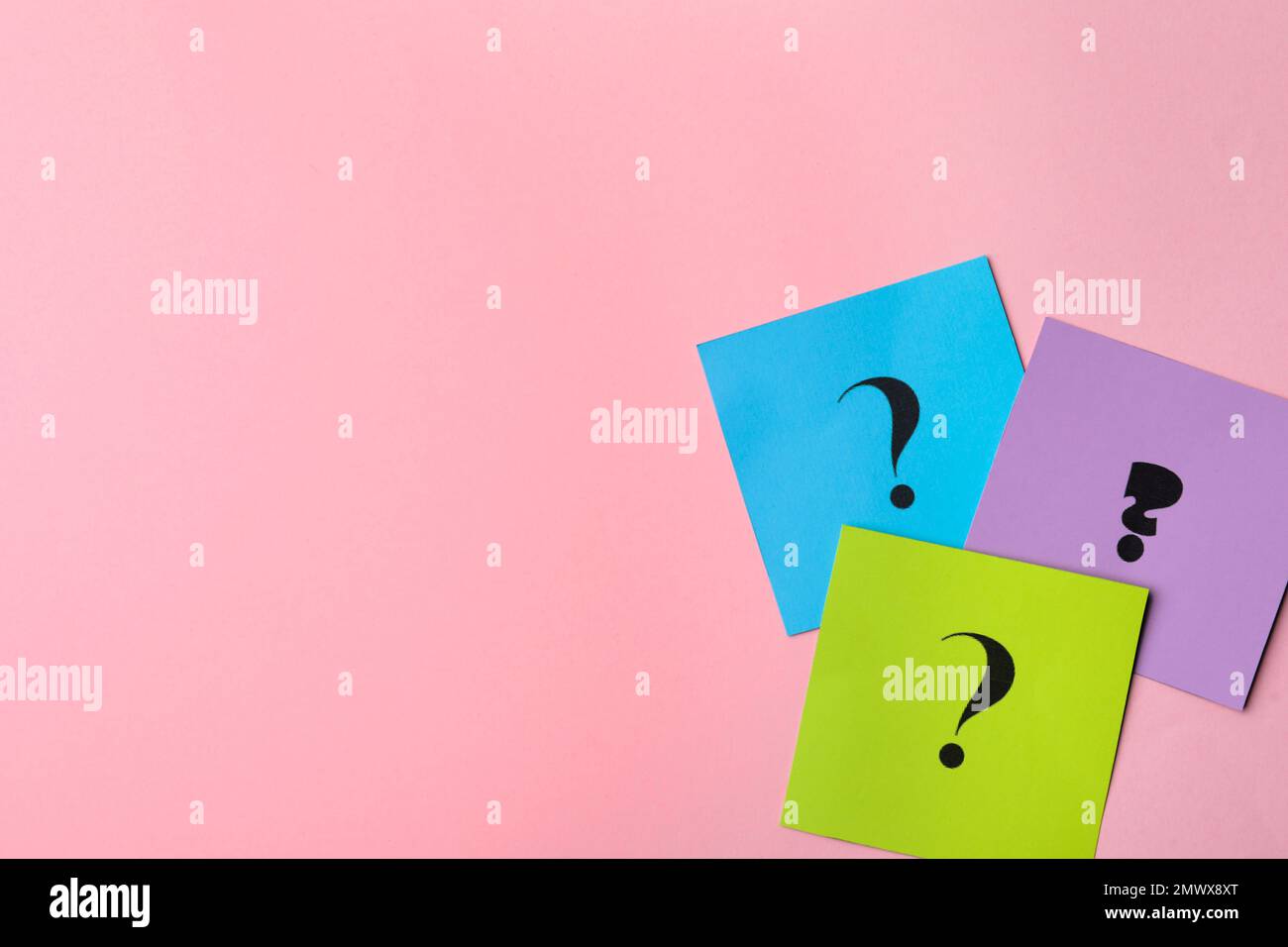 Paper cards with question marks on pink background, flat lay. Space for ...