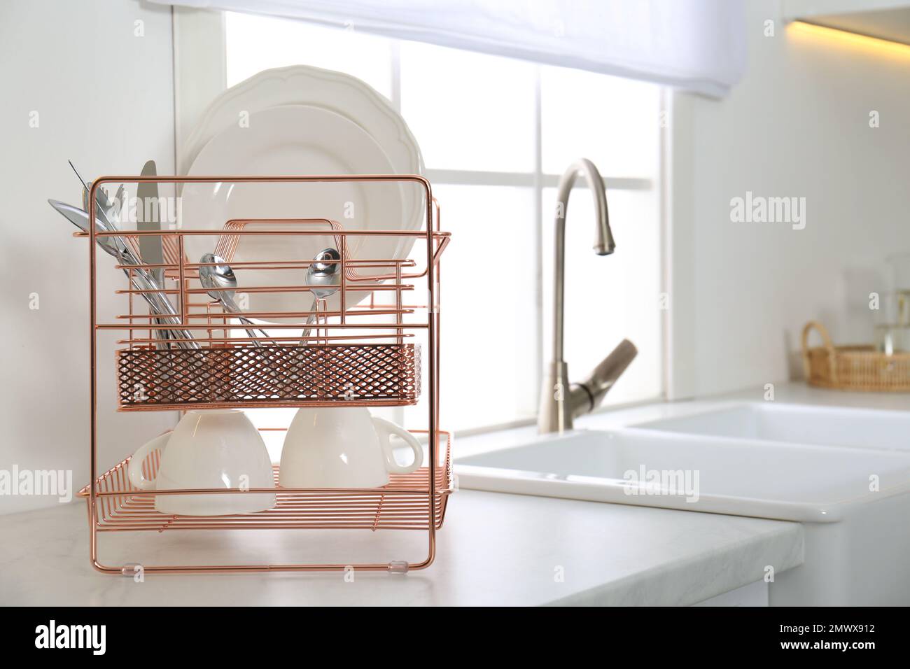 Clean dishes on drying rack in modern kitchen interior Stock Photo - Alamy