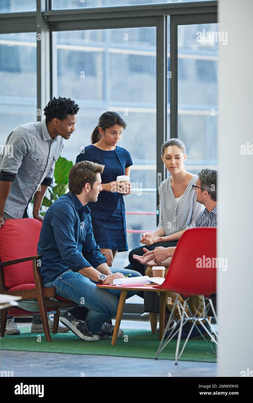 Strategy in action. a group of office workers talking together in a ...