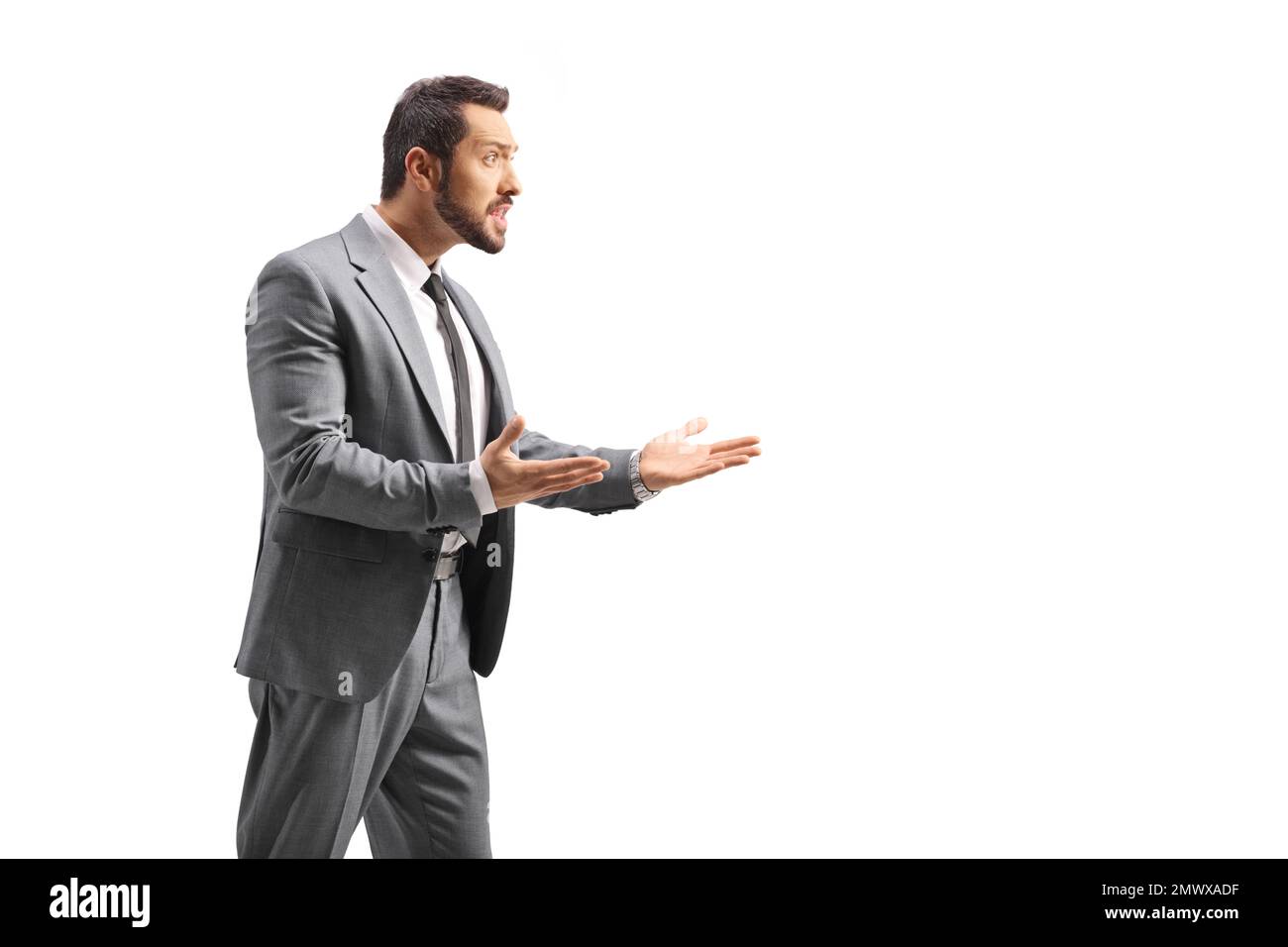 Angry businessman in a gray suit gesturing with hands isolated on white ...