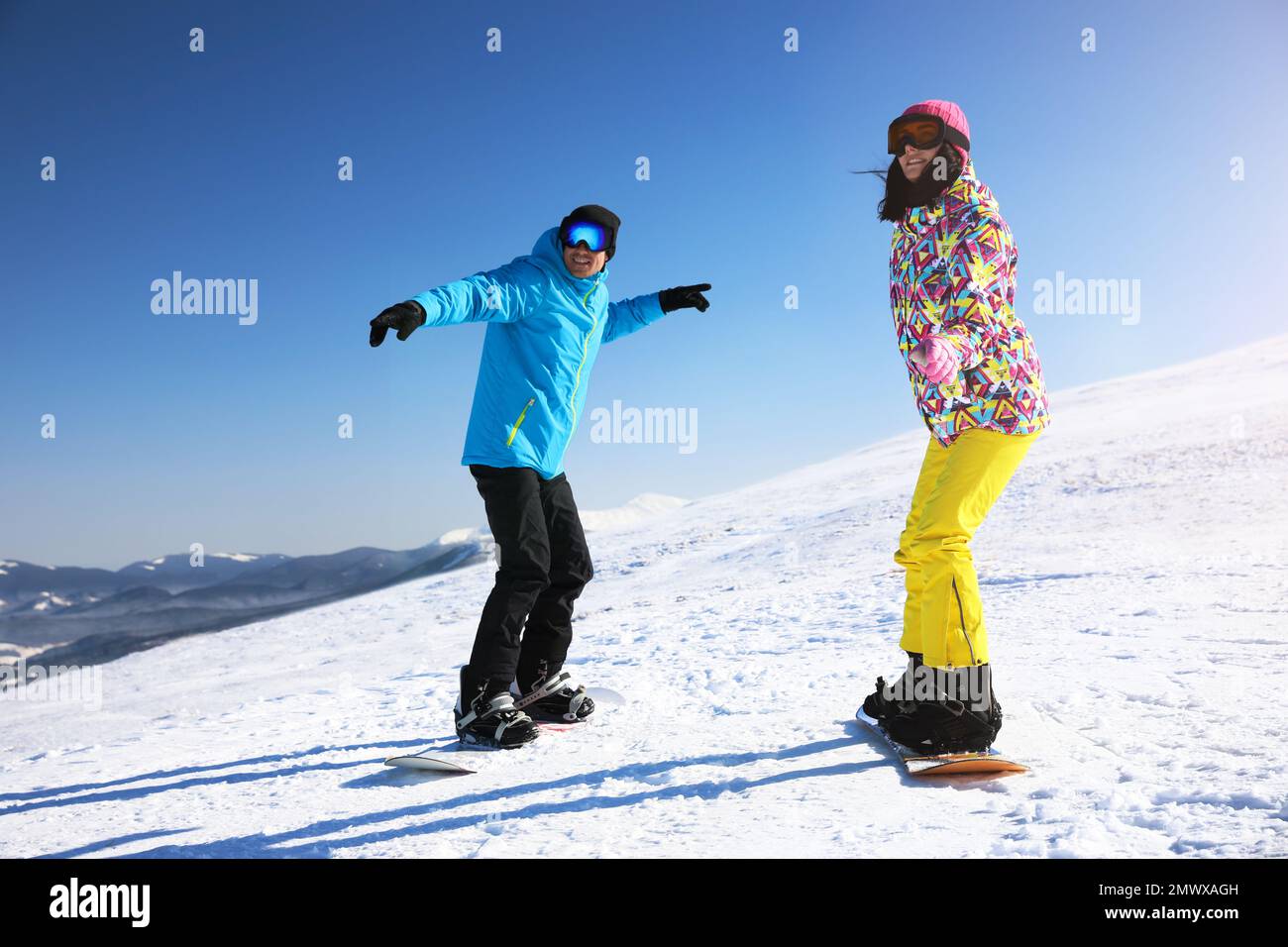 Couple snowboarding on snowy hill. Winter vacation Stock Photo - Alamy