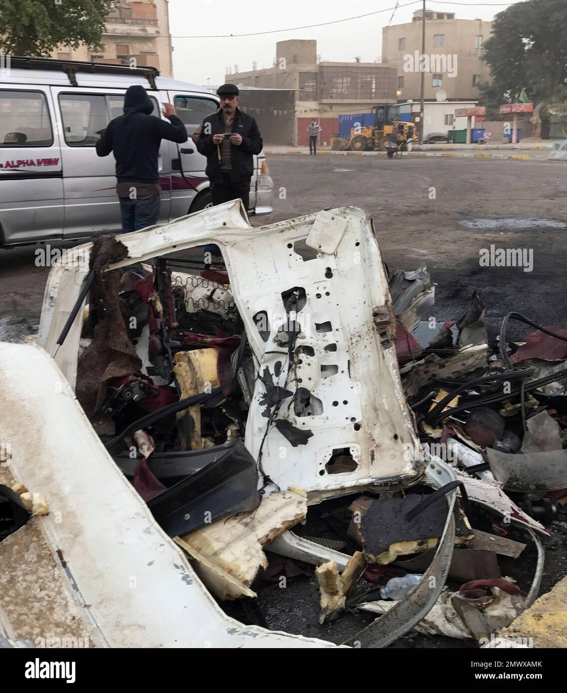People inspect the aftermath of a car bomb in Baghdad, Iraq, Sunday ...