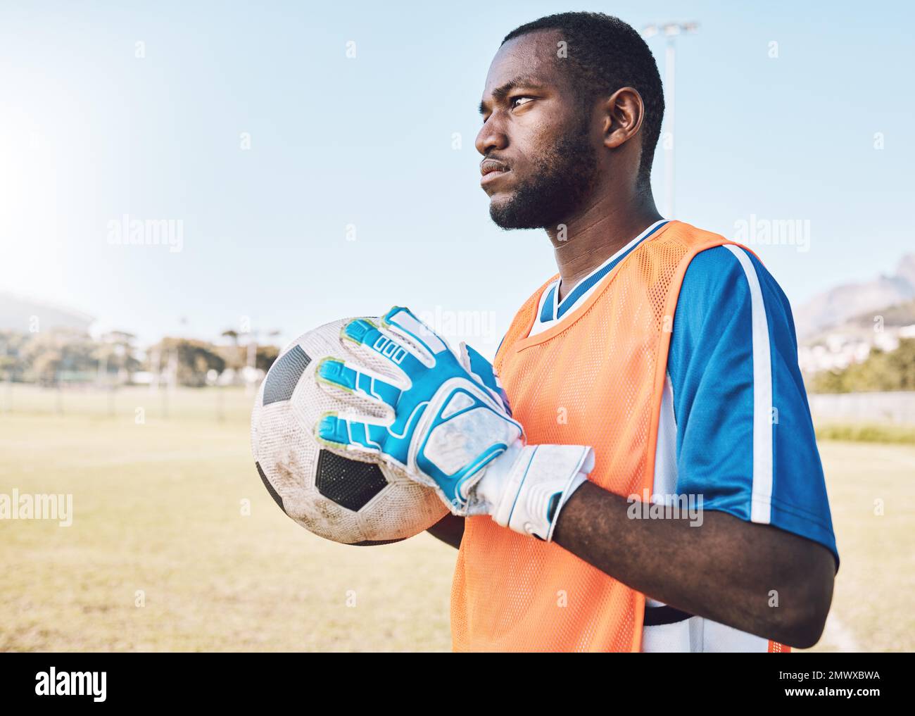 Black man, football and goalkeeper training on field for focus ...