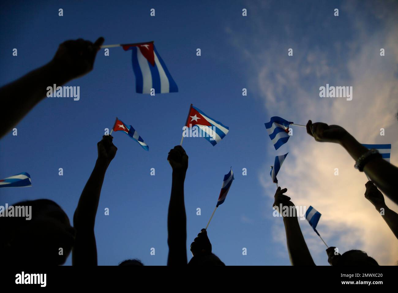 People wave Cuban flags before a rally honoring the late Fidel Castro ...