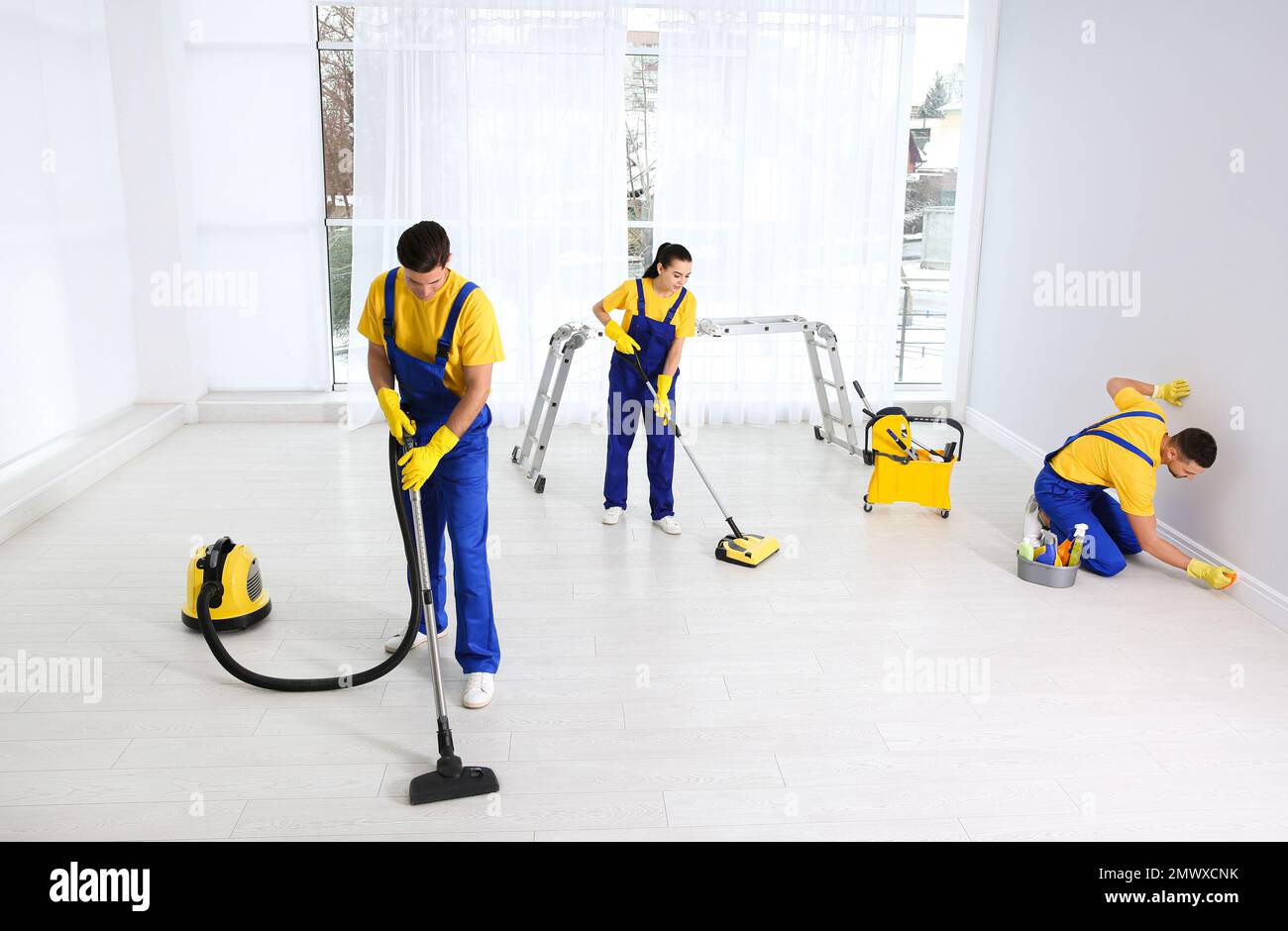 Team of professional janitors cleaning room after renovation Stock ...
