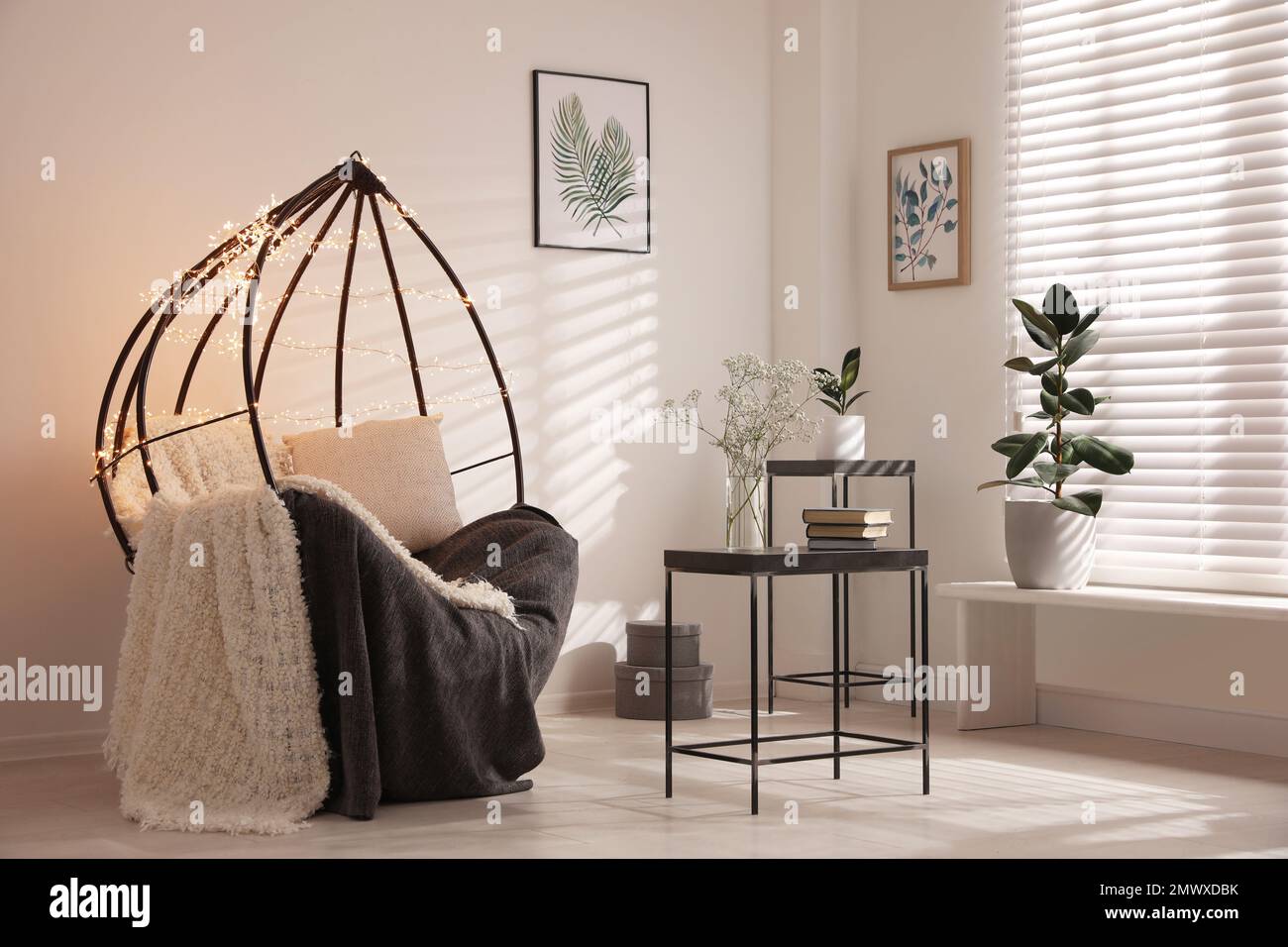 Cozy hanging chair with fairy lights in modern living room. Interior ...