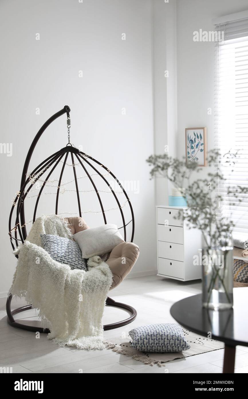 Cozy hanging chair with fairy lights in modern living room. Interior ...