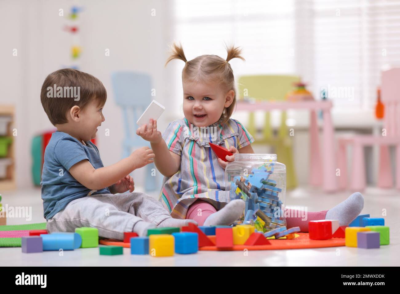 Cute little children playing together on floor at home Stock Photo - Alamy