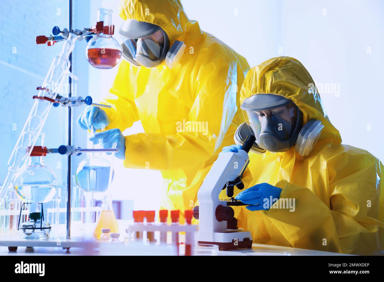 Scientists in chemical protective suits working at laboratory. Virus ...