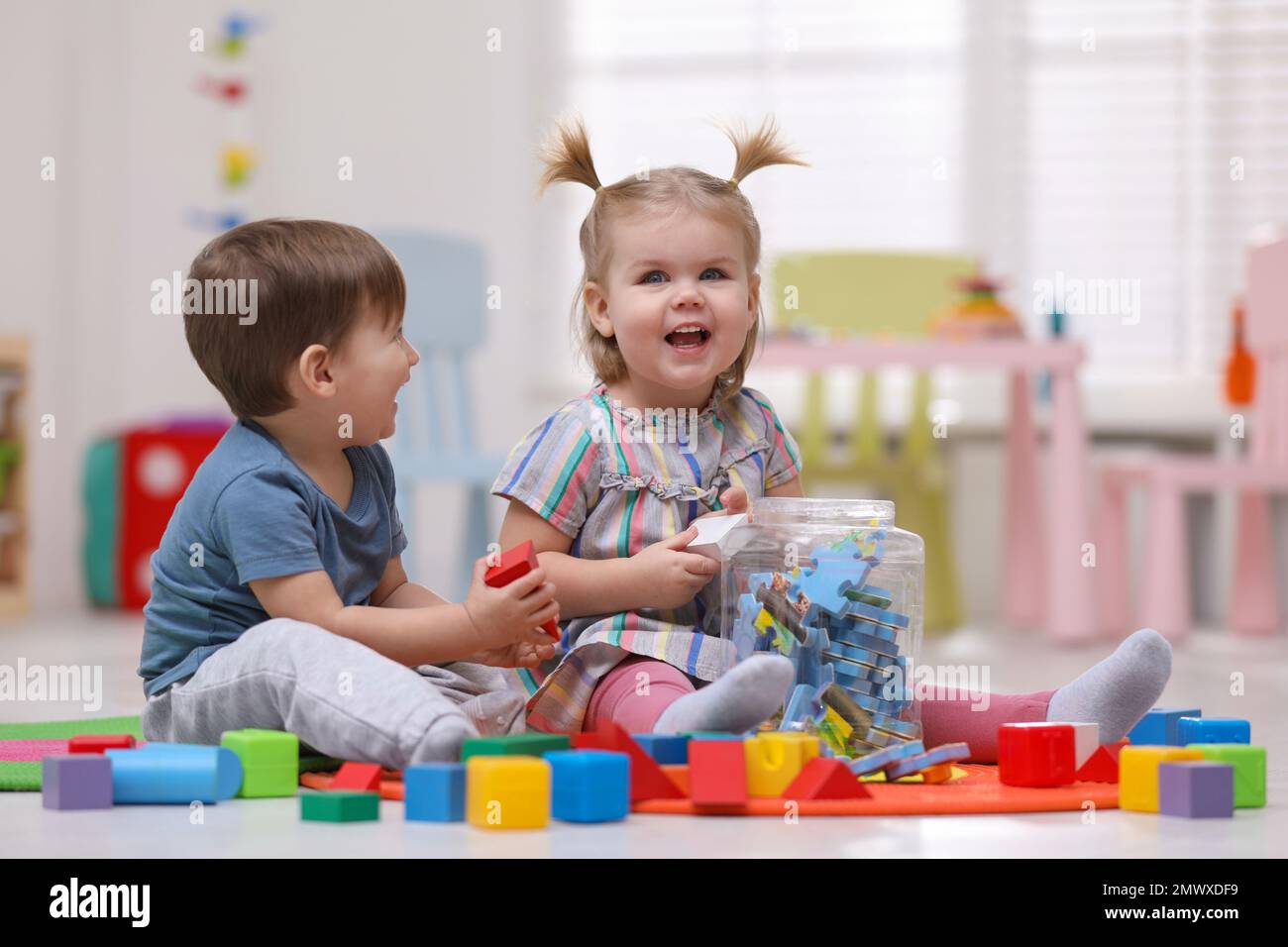 Cute little children playing together on floor at home Stock Photo - Alamy