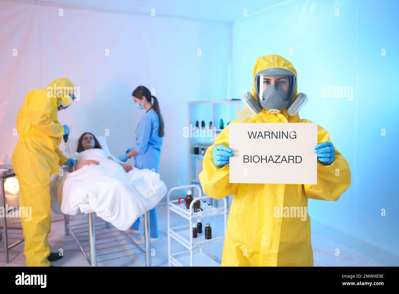 Paramedic holding sign with words WARNING BIOHAZARD in quarantine ward ...