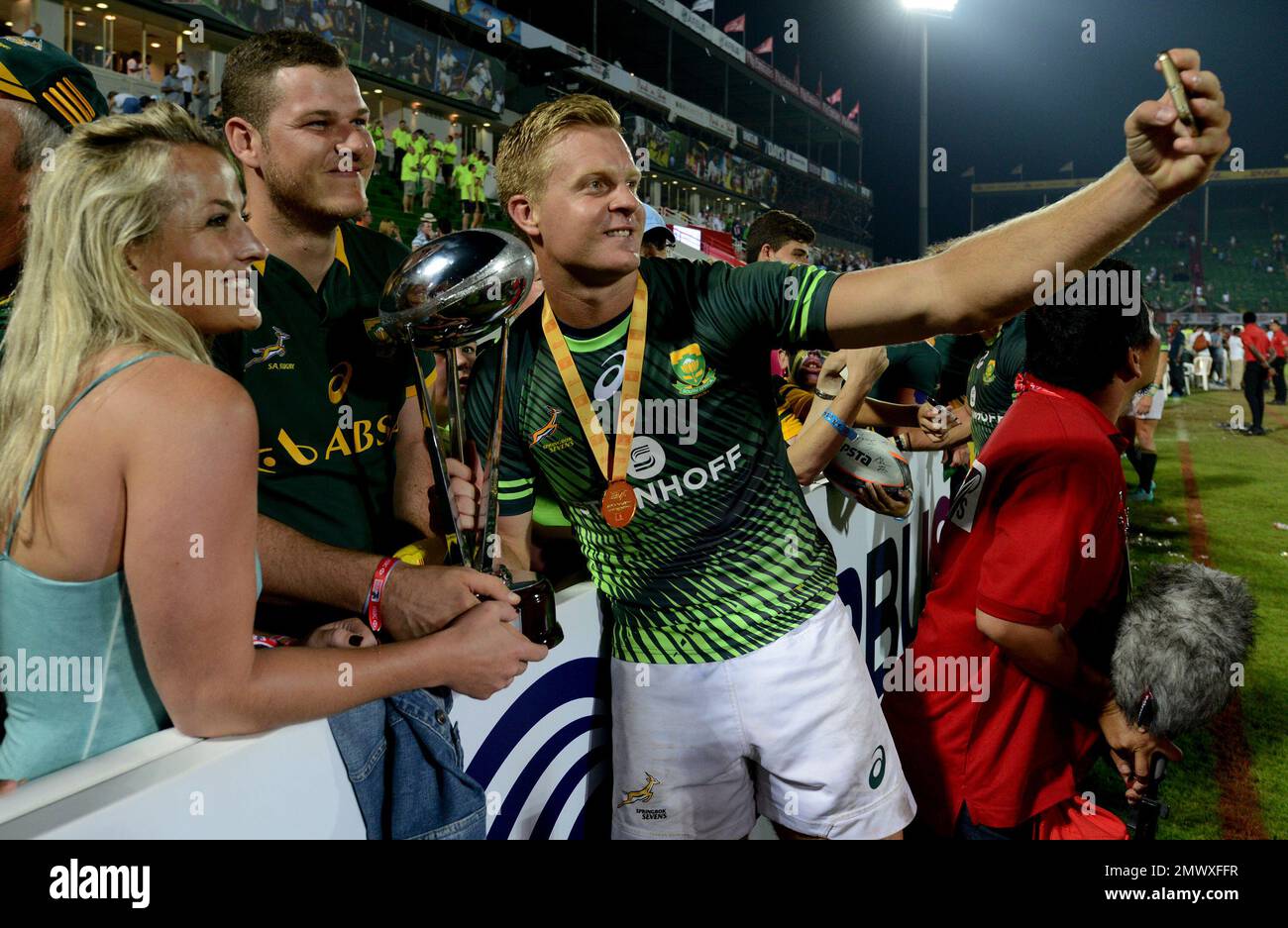 South Africa's Dylan Sage takes a picture with the trophy and two fans ...