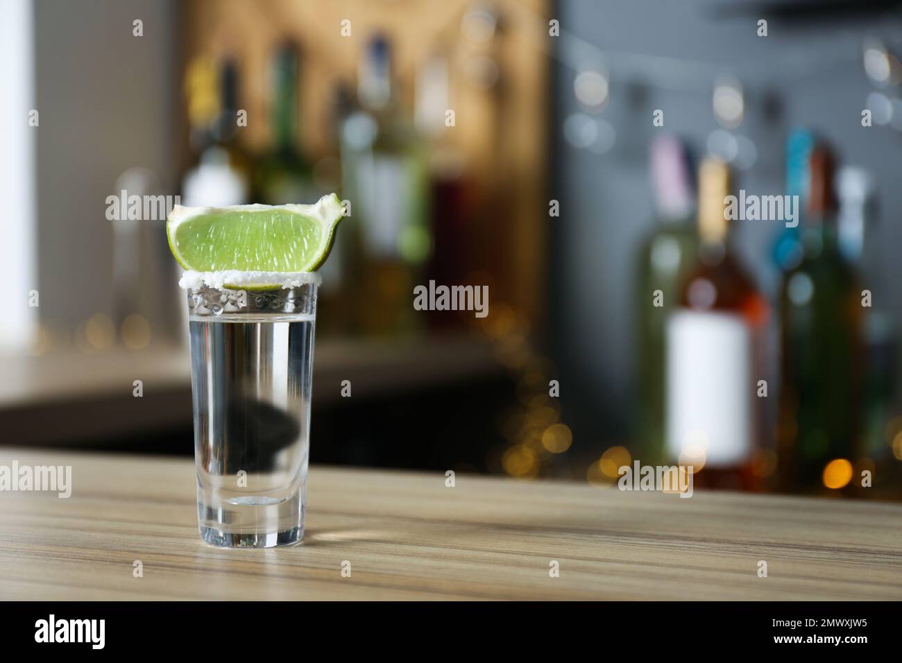Mexican Tequila with salt and lime slice on bar counter. Space for text ...