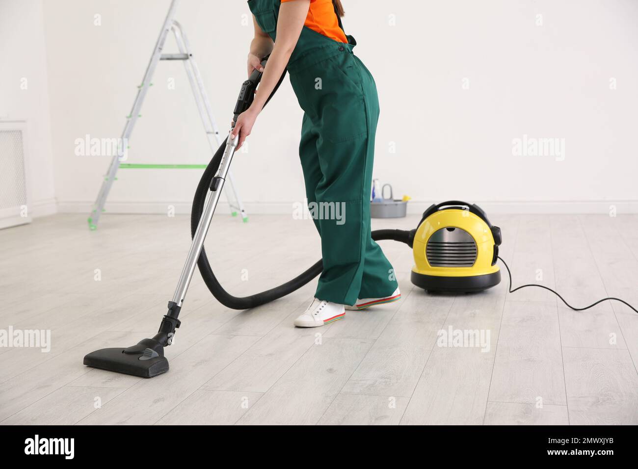 Professional young janitor vacuuming indoors. Cleaning service Stock ...
