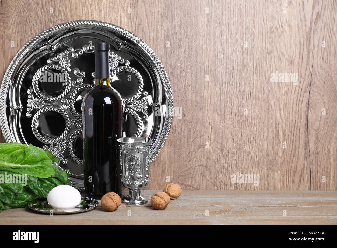Symbolic Pesach (Passover Seder) items on wooden table, space for text ...