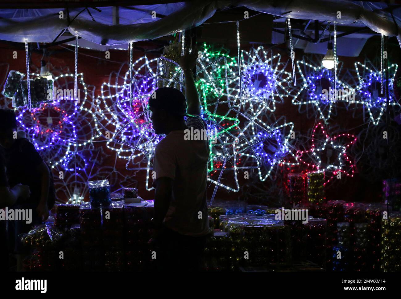 A Filipino Christmas lights vendor waits for customers at their ...