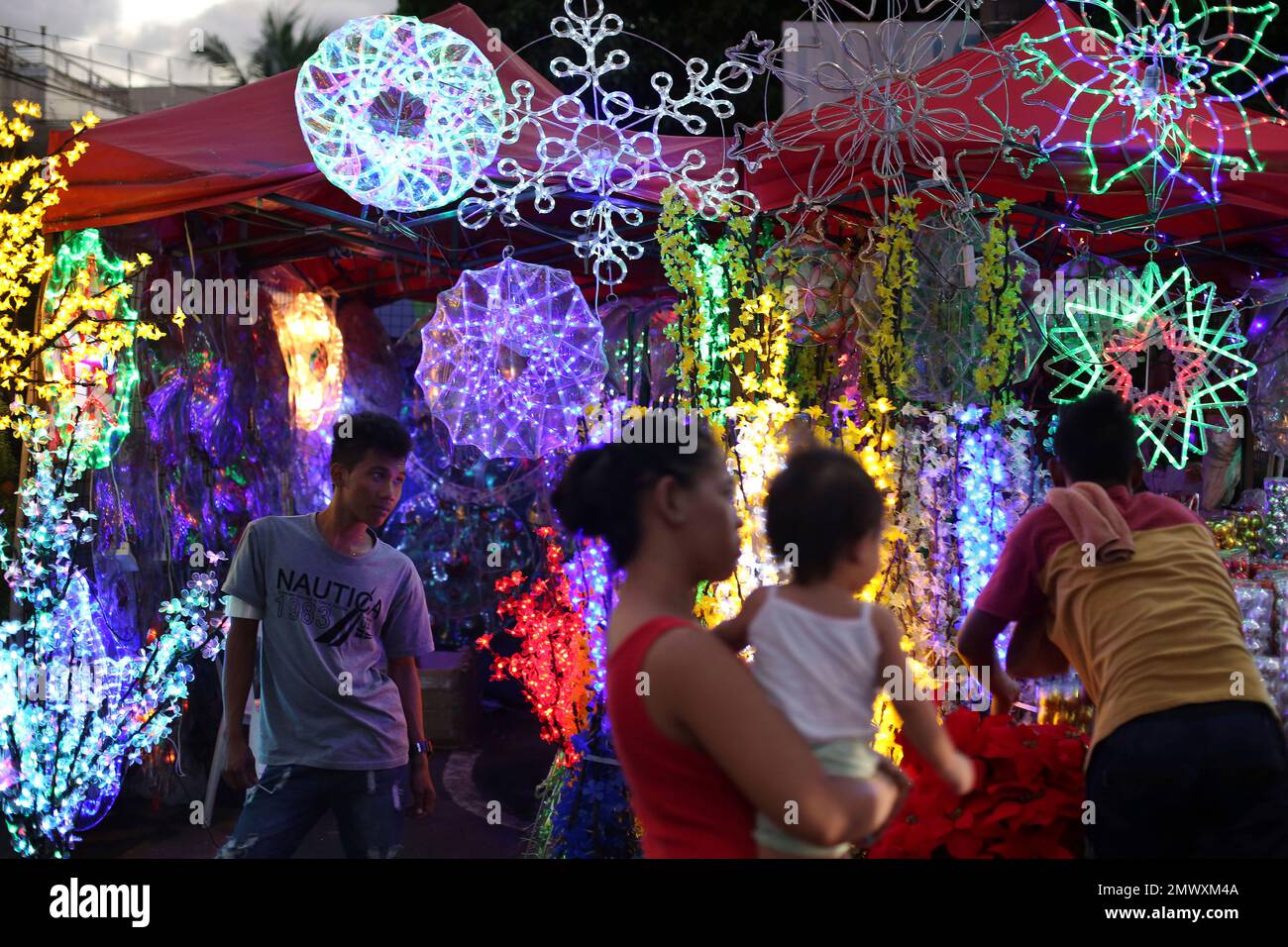 A Filipino Christmas lights vendor watches as people pass by their ...