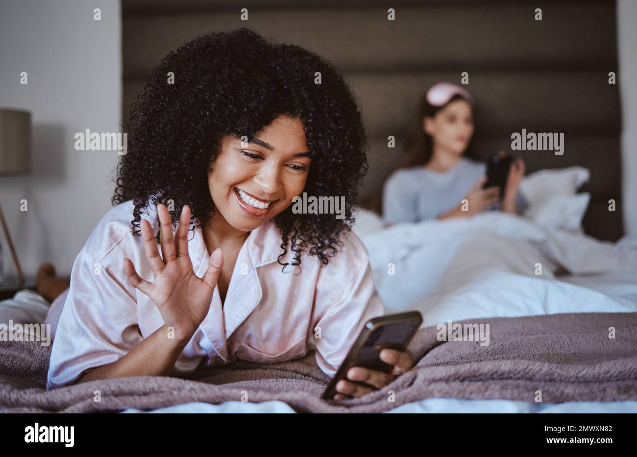 Video call, phone and wave with black woman at sleepover for ...