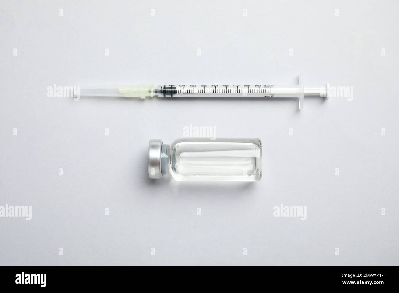 Vial and syringe on light background, flat lay. Vaccination and ...
