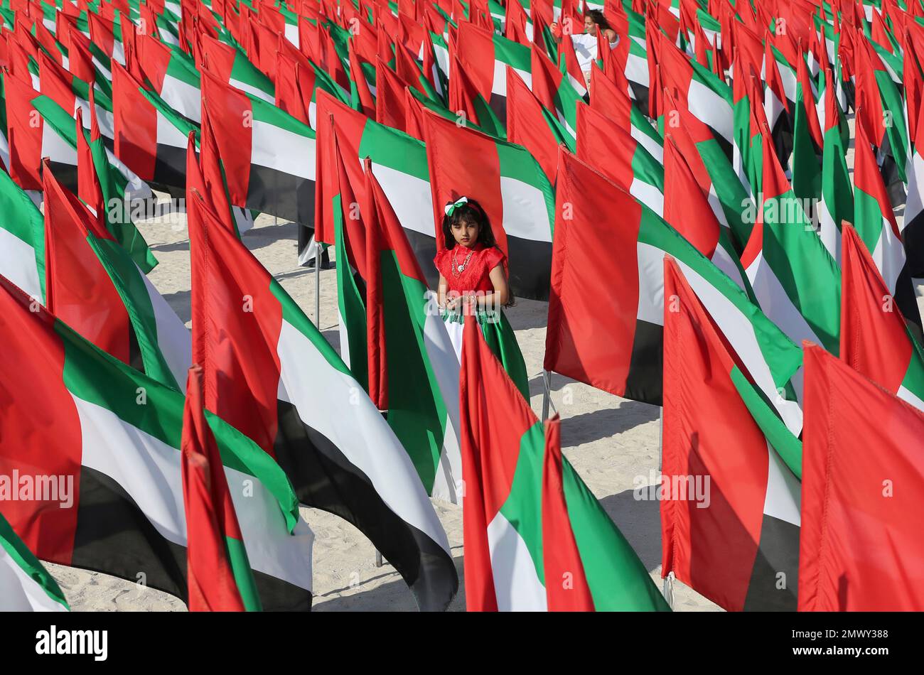 An Emirati girl walks inside the "Flags Garden" features 4000 UAE flags ...