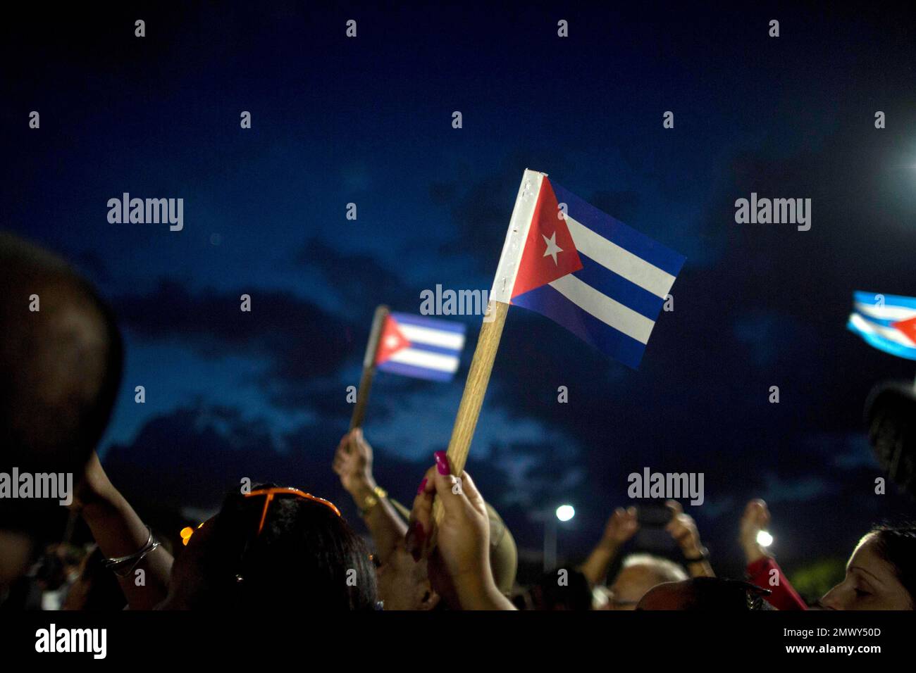 Participants hold Cuban flags during a rally honoring the deceased ...