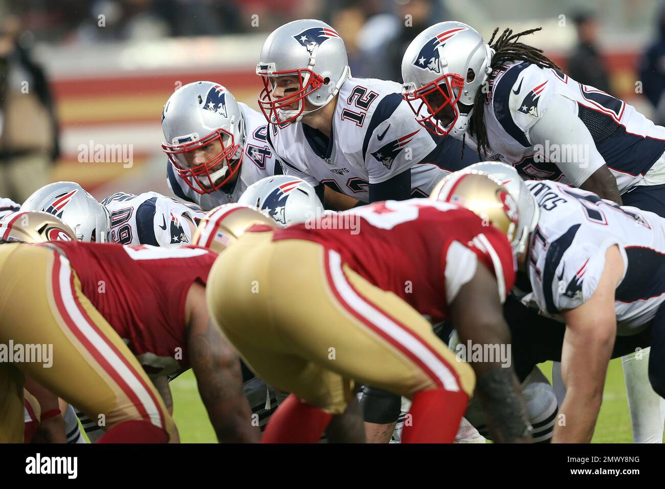 New England Patriots quarterback Tom Brady (12) is flanked by James ...