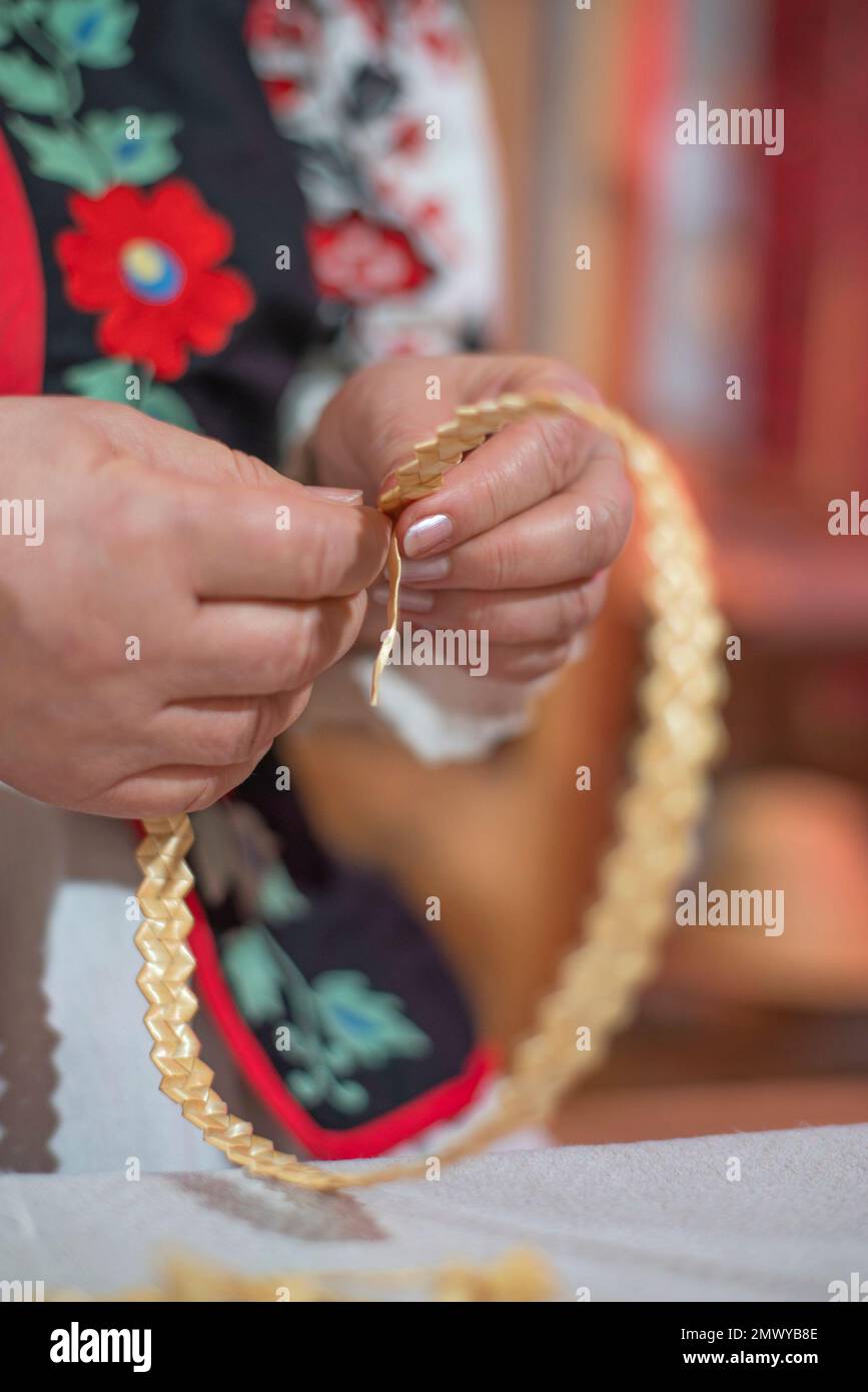 The woman's hands weave straw. traditional craft Stock Photo - Alamy