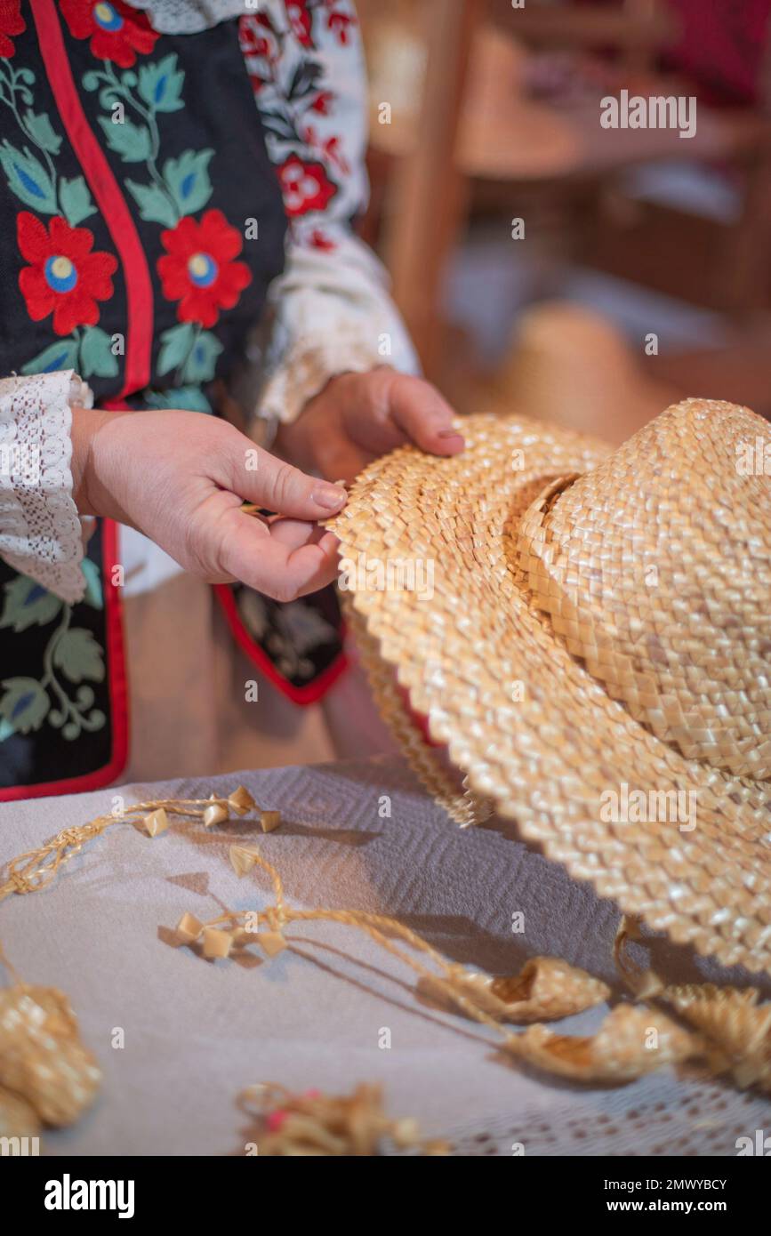 woman craftsman weaves a hat out of straw. folk craft Stock Photo - Alamy