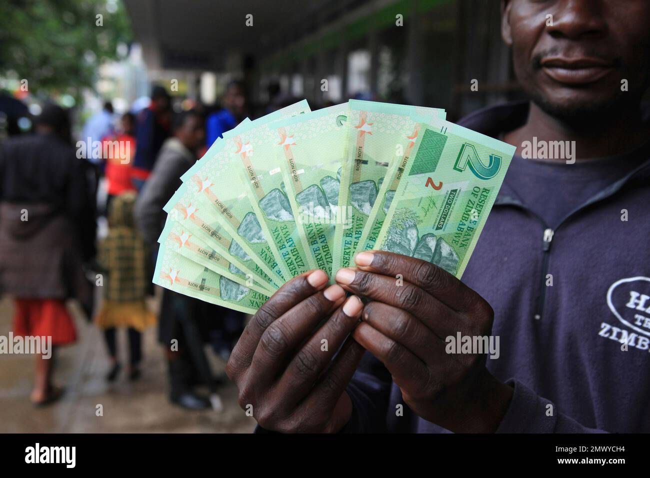 A man shows the new notes introduced by the Reserve Bank of Zimbabwe in ...