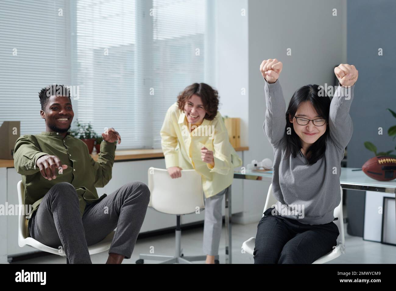 Group of happy colleagues playing and having fun together in office ...
