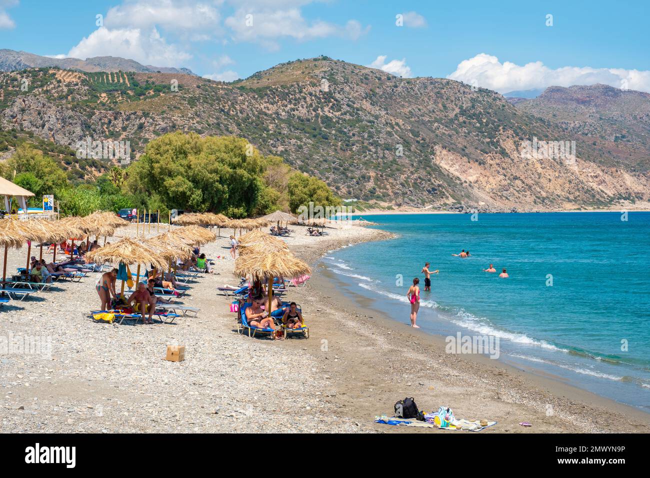 Tourists rest on the pebble beach of Chalikia in Paleochora. Crete ...