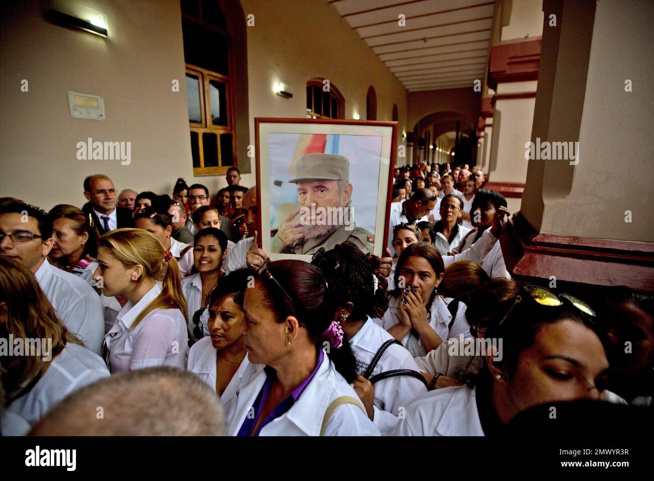 Cuban doctors working in Venezuela, hold a photo of Cuba's former ...