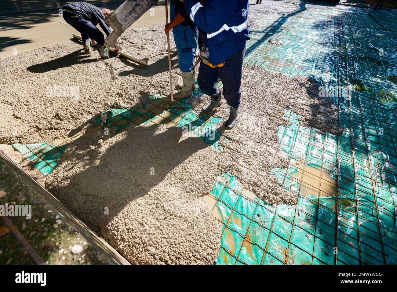 Construction worker is directing the pump tube on right direction ...