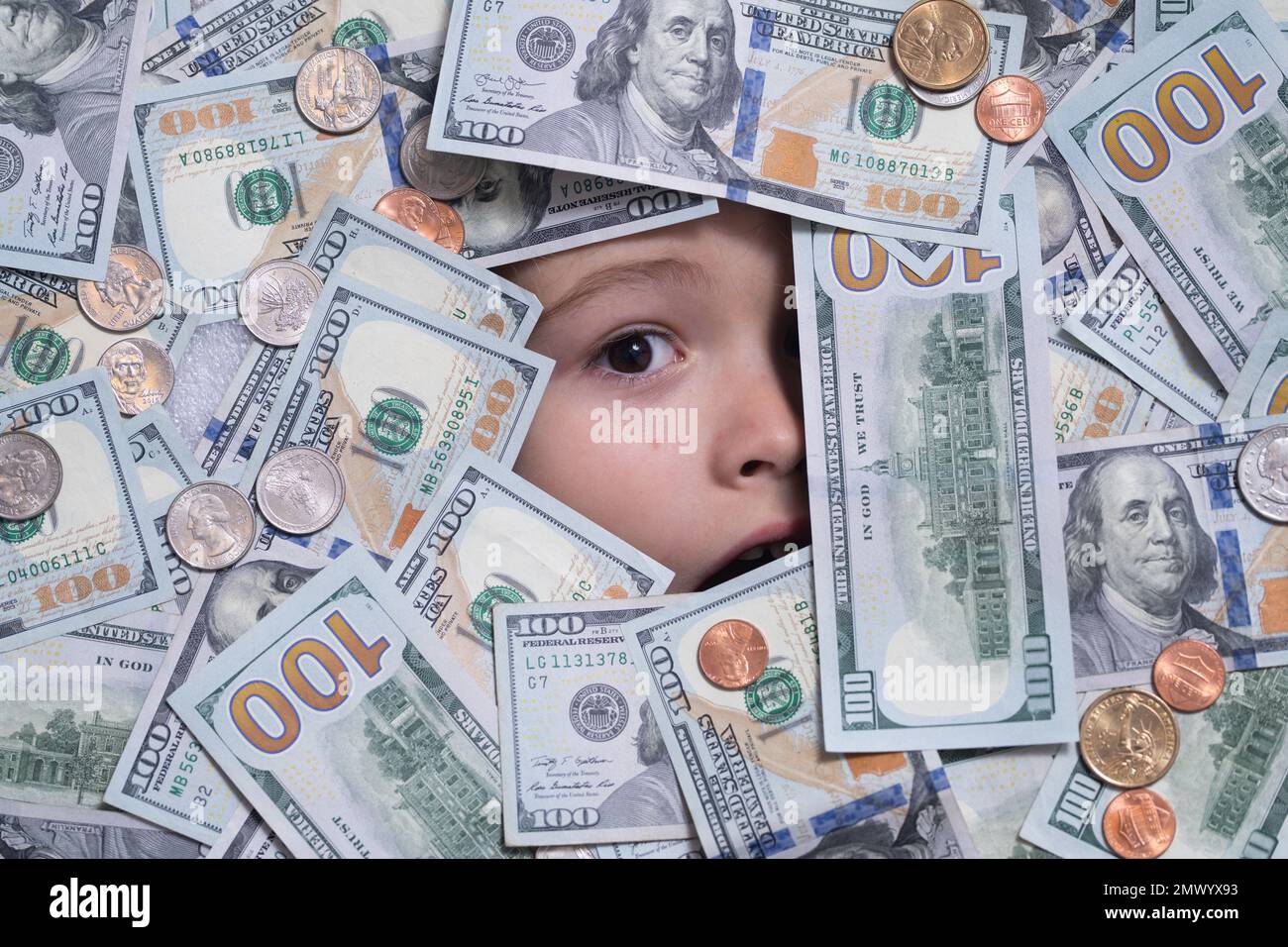 Funny child face in money dollars banknotes background Stock Photo - Alamy