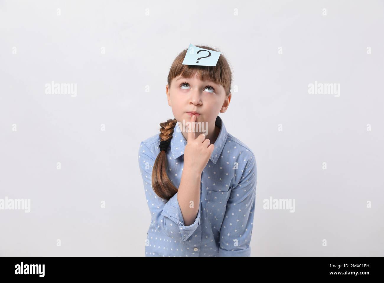 Emotional girl with question mark sticker on forehead against white ...