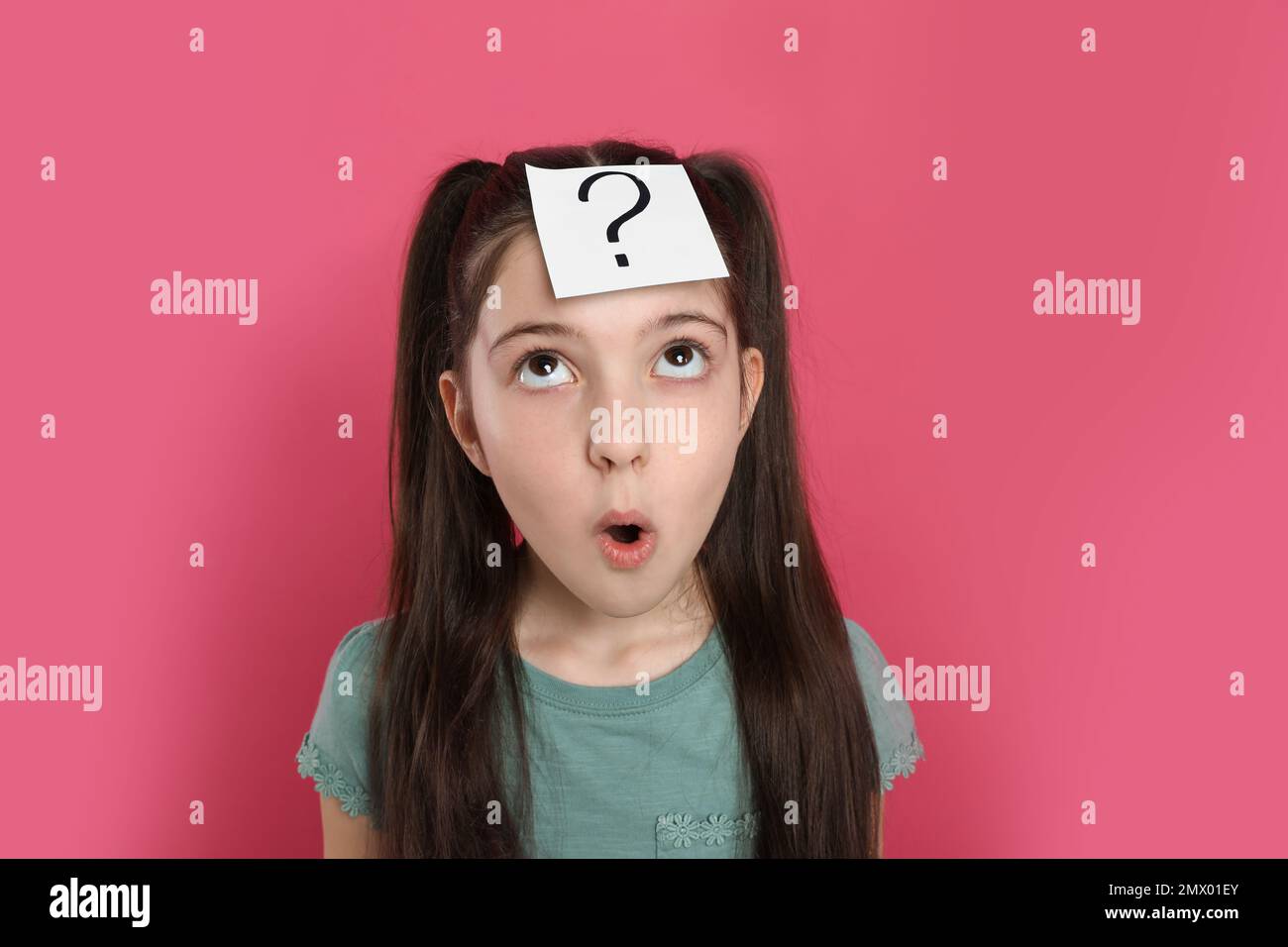 Emotional girl with question mark sticker on forehead against pink ...