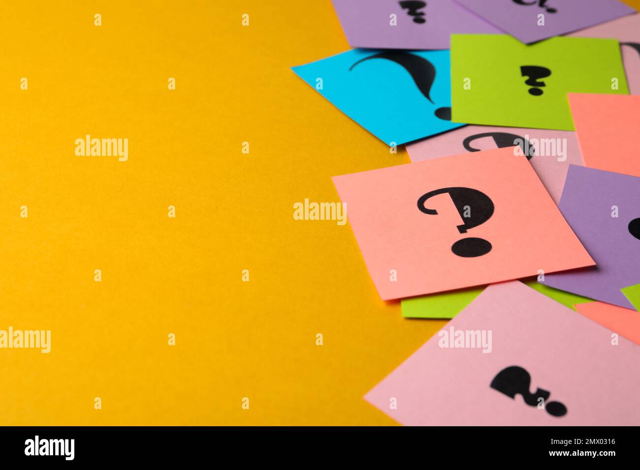 Paper cards with question marks on yellow background, closeup. Space ...