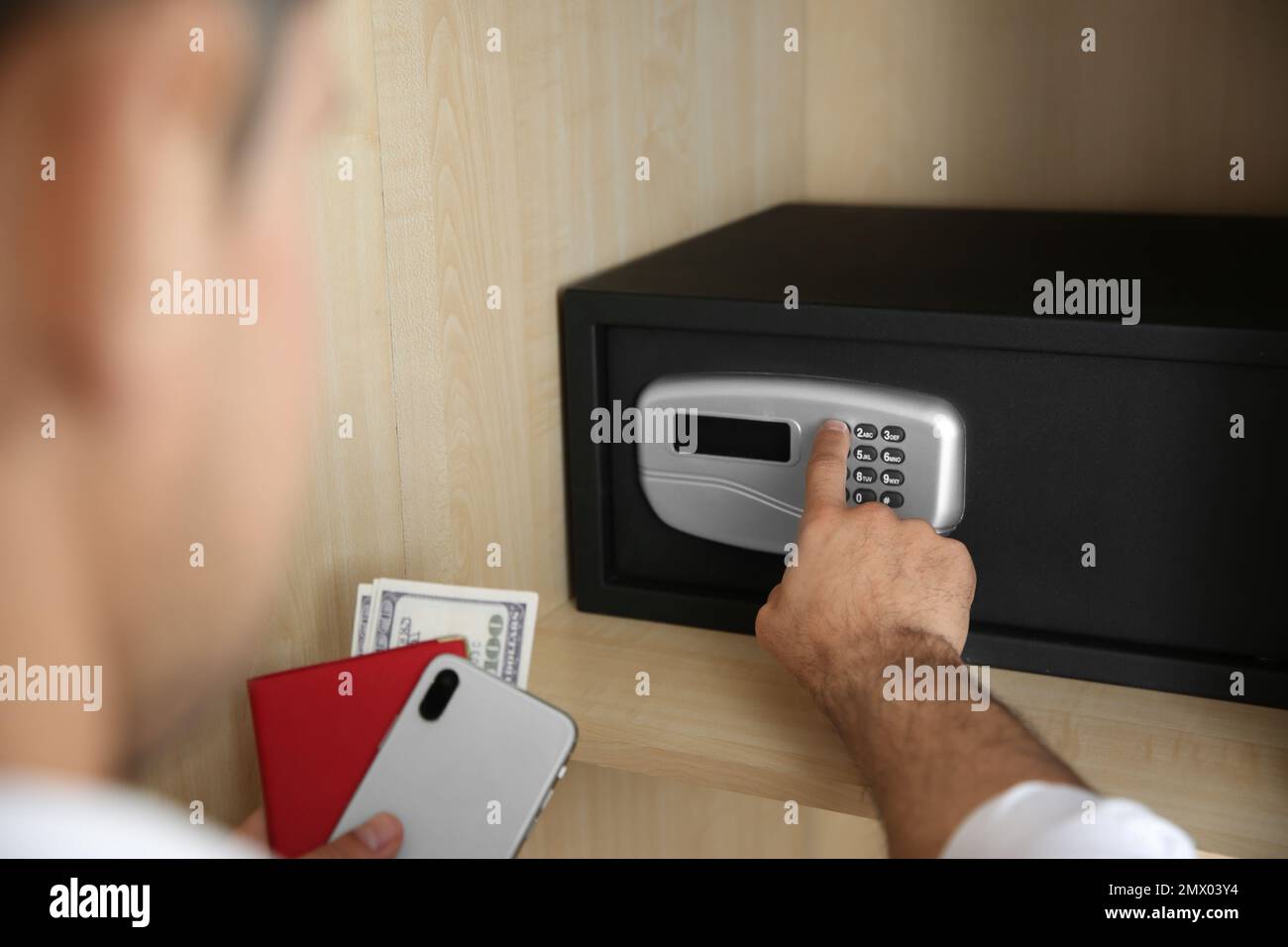 Man opening black steel safe with electronic lock at hotel, closeup ...