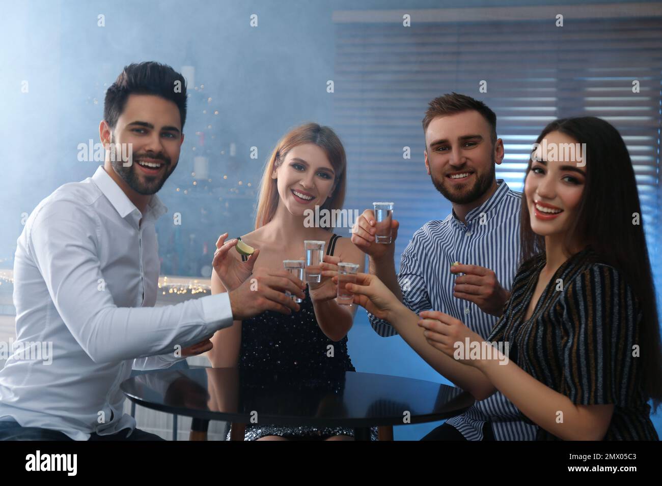 Young people toasting with Mexican Tequila shots at table in bar Stock ...