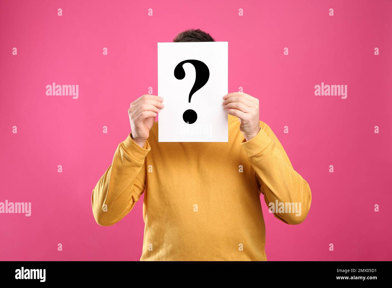 Man holding paper with question mark on pink background Stock Photo - Alamy