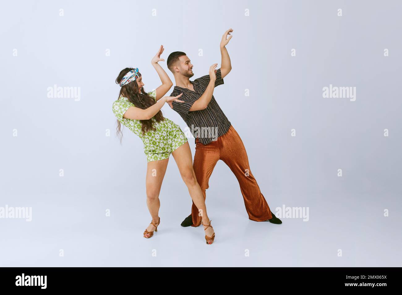 Synchronized movements. Emotional young man and woman in sytlish retro ...