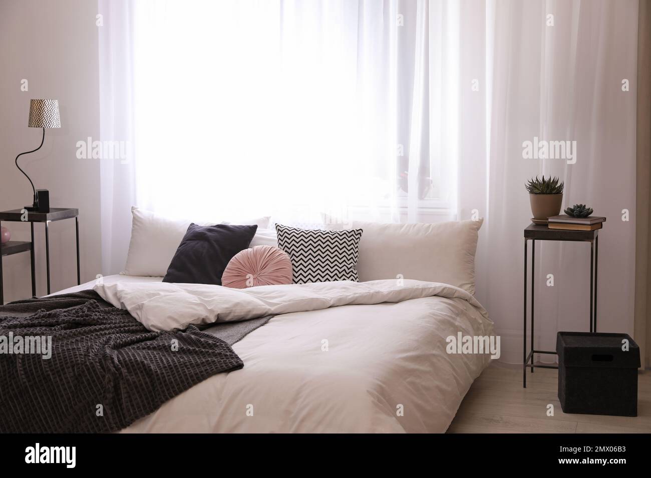 Large comfortable bed in stylish room interior Stock Photo - Alamy
