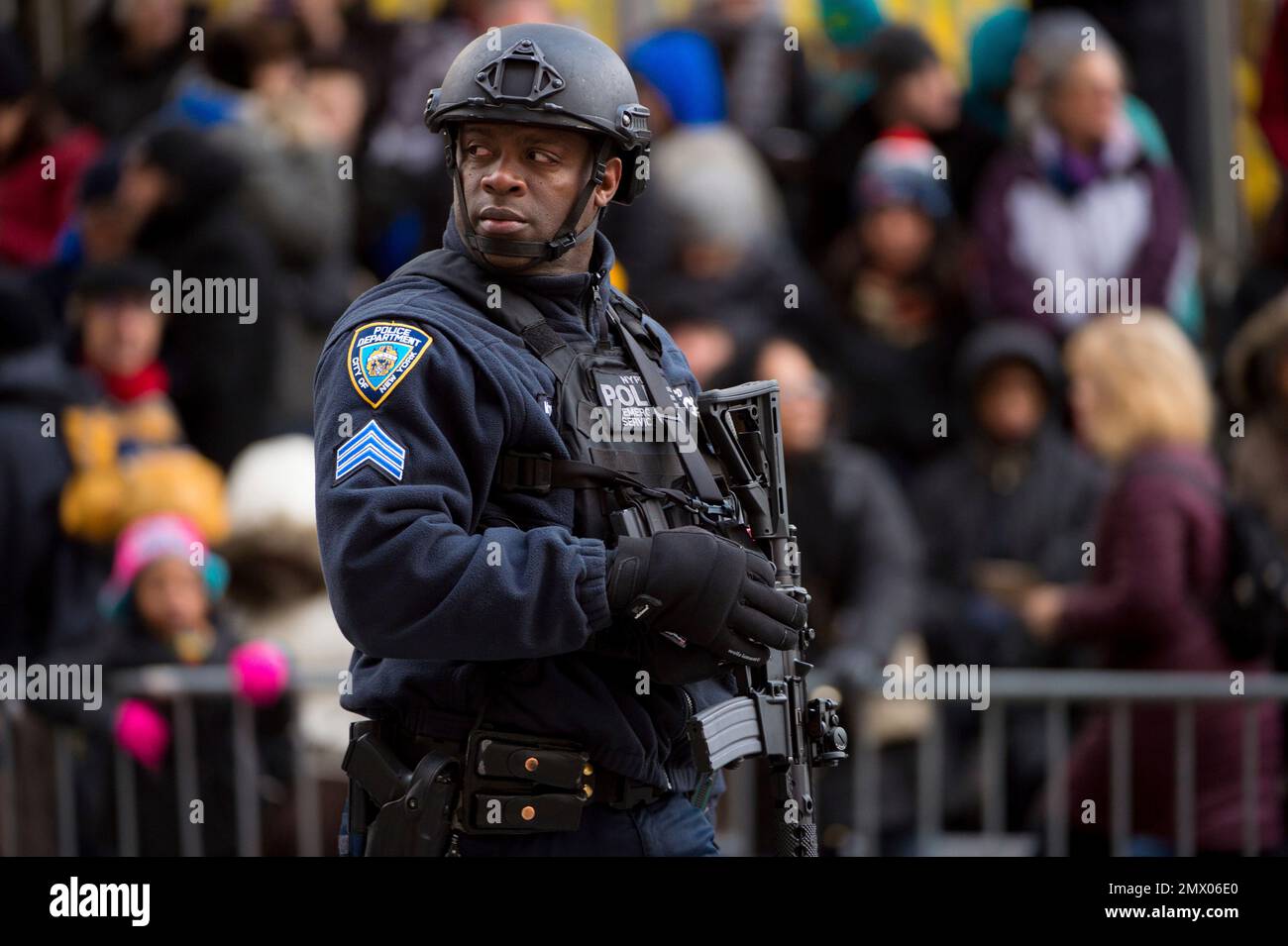 An NYPD police officer stands guard on the parade route on 59th Street ...