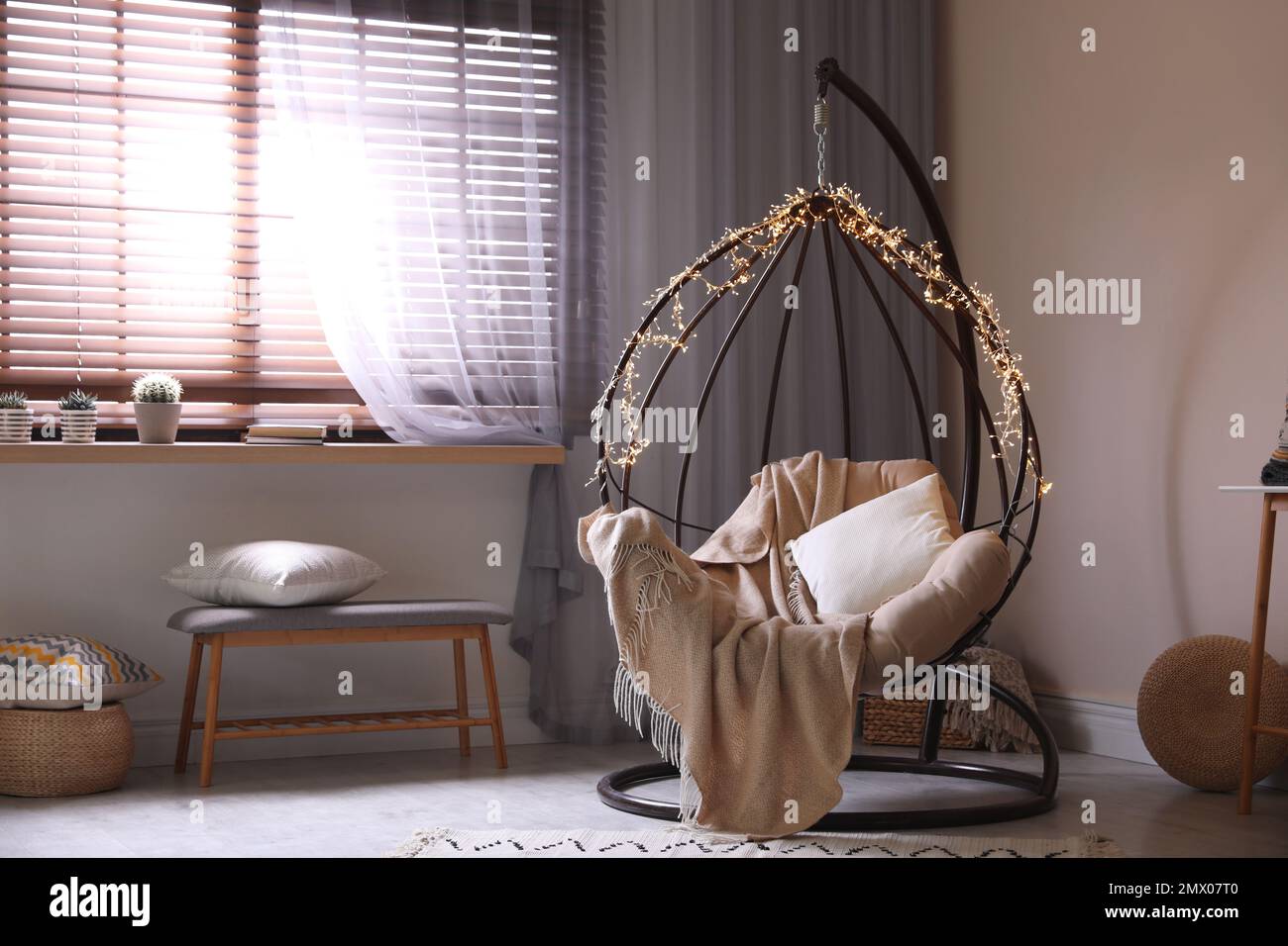 Cozy hanging chair with fairy lights in modern living room. Interior ...